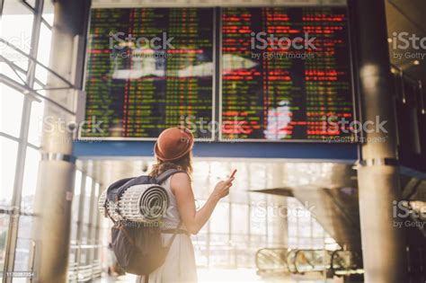 테마 여행 과 트라노 스포츠 빨간 전화를 들고 일정을 보고 기차역 이나 터미널 안에 서 드레스와 배낭에 아름 다운 젊은 백인 여자 통신 기술을 사용 하 여 가방에 대한 스톡