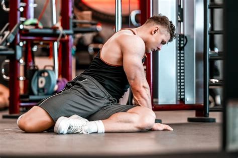 Premium Photo Athlete Stretches After Training In Gym