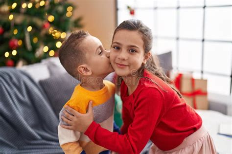 Hermano Y Hermana Bes Ndose Y Abraz Ndose Unos A Otros Parados Junto A Un Rbol De Navidad En