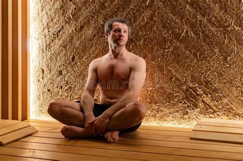 A Mature Man With A Naked Torso Relaxes In A Sauna A Muscular Man Sits