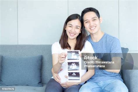 초음파 임신 한 엄마와 아빠 남편과 함께 행복한 임산부는 아기의 스캔을 보여줍니다 행복한 부부는 아기 초음파 사진을 들고있다