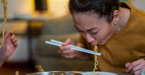 아름다운 아시아 여자 친구들은 소시지와 함께 인스턴트 라면을 먹고 밤에 거실에서 함께 이야기합니다 여성 커플 여자 친구는 집에서 함께 저녁 식사를하면서 실내 라이프