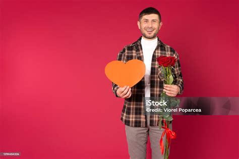 세인트 발렌타인 데이에 장미 꽃다발과 붉은 마음을 가진 잘 생긴 젊은 남자 빨간색 배경과 빈 측면 공간입니다 2월에 대한 스톡 사진 및 기타 이미지 Istock