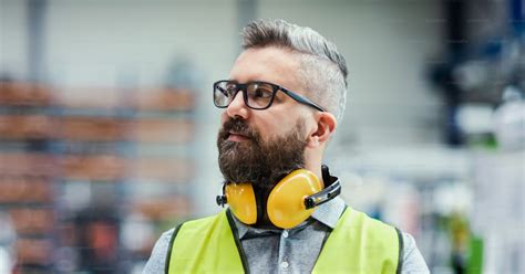 산업 공장에 서 있는 보호 헤드폰을 가진 기술자 또는 엔지니어 공간을 복사합니다 사진 Unsplash의 사진술 이미지