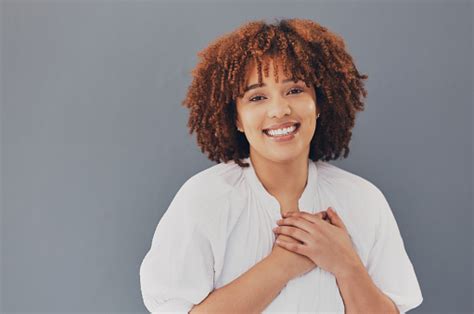 흑인 여성 초상화와 얼굴은 사랑 보살핌 자선 지원을 위해 가슴이나 심장에 손을 얹고 있습니다 감사 친절 신뢰를 위해 손을 든 아프리카 사람의 얼굴 또는 회색 배경에