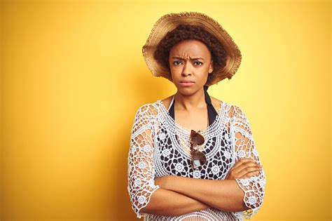 흰색 고립 된 배경 회의적이고 긴장 교차 팔로 얼굴에 표정을 거부 하는 흰색 고립 된 배경 위에 여름 모자를 입고 아프리카 계