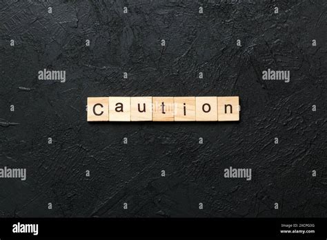 Caution Word Written On Wood Block Caution Text On Cement Table For