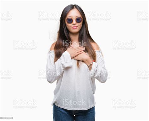 젊은 아시아 여자와 웃 고 고립 된 배경 위에 선글라스를 쓰고 얼굴에 닫힌된 눈와 감사와 함께 가슴에 손 건강 개념입니다 감사에 대한 스톡 사진 및 기타 이미지 Istock