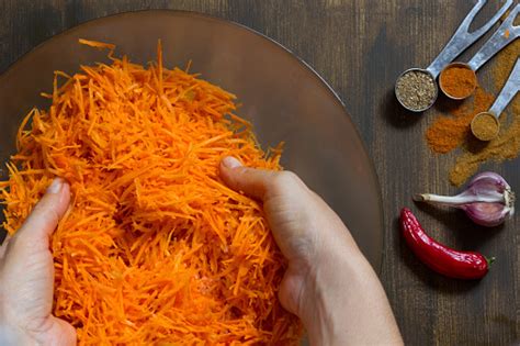 매운 한국 당근 샐러드 유리 그릇에 강판 당근을 들고 여자의 손의 상단보기 갈색에 대한 스톡 사진 및 기타 이미지 갈색 강판에 갈기 고수씨 Istock