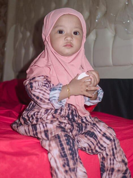 Premium Photo Portrait Of Cute Girl Sitting On Bed At Home