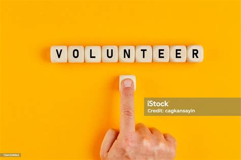 나무 블록에 나무 블록에 쓰여진 단어 자원 봉사자는 버튼을 누르는 남성의 손으로 자원 봉사와 합류의 개념 개념에 대한 스톡 사진 및 기타 이미지 Istock