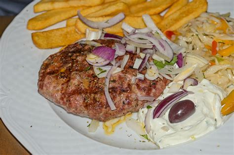 구운 비프테키 감자튀김 샐러드 짜치키를 곁들인 그리스 미트볼 생양파를 곁들인 요리 그리스 레스토랑이나 패스트푸드 그릴의 대표 요리 엄선된 초점 가루로 빻은에 대한 스톡 사진