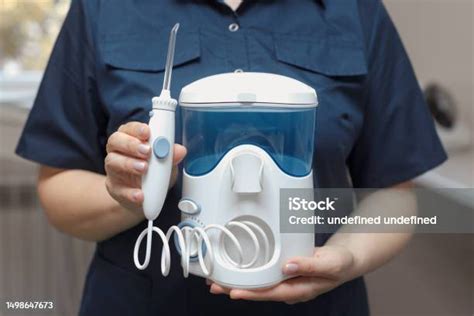 치과 의사는 치아의 청소 및 위생을 위해 물 구강 세정기를 손에 들고 있습니다 얼굴 없음 구강 세정기에 대한 스톡 사진 및 기타 이미지 구강 세정기 전기 칫솔 치과