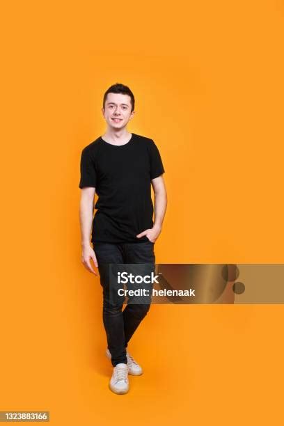 노란 배경에 서 있는 검은 옷을 입은 남자의 전체 길이 초상화 25 29세에 대한 스톡 사진 및 기타 이미지 25 29세 T 셔츠 검은색 Istock
