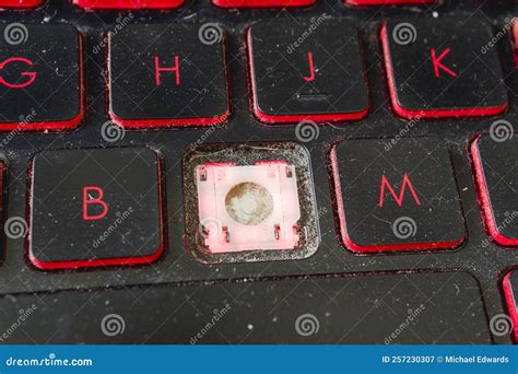 Closeup Of A Dirty And Neglected Laptop Keyboard With Red Accents With A Missing Key Covered In