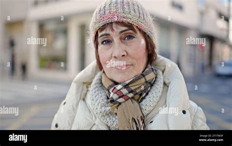 Mature Hispanic Woman Standing With Serious Expression At Street Stock