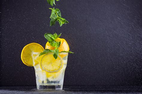 플라잉 민트와 레몬레모네이드 어두운 배경에 레몬여름 상쾌한 음료 시트러스와 민트가 들어간 물 공중 부양 수평 감귤류 과일에 대한 스톡 사진 및 기타 이미지 Istock