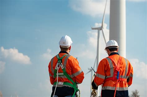 측량사 및 엔지니어 풍력 에너지를 일상 생활에서 사용되는 전기 에너지로 변환하는 거대한 풍력 터빈의 효율성을 조사합니다 2명에 대한 스톡 사진 및 기타 이미지 Istock