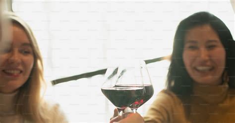 젊은 쾌활한 아시아 여성이 레스토랑에서 저녁 식사를 하는 테이블 위에 있는 친구들 사이에서 남자친구와 레드 와인 한 잔을 마시며 울부짖는다 사진 Unsplash의 기쁨 이미지