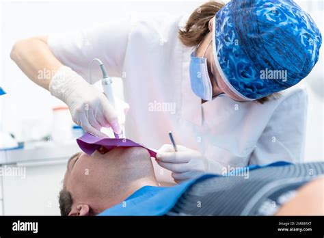 Dental Clinic A Doctor Performing A Root Canal To A Patient In Full