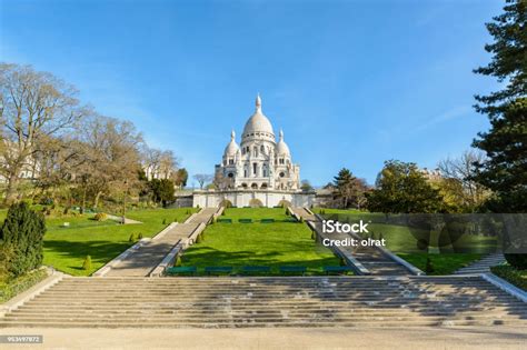 신성한 심 혼의 파리의 루이스 미셸 공원 화창한 봄 아침에 계단의 아래에서 몽 마 르 뜨 언덕의 상단에 위치한 밝은 흰색 대성당의 전면 보기 사크레쾨르 대성당에 대한 스톡