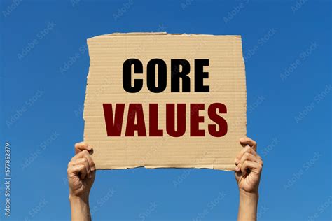 core values text on box paper held by 2 hands with isolated blue sky background this message
