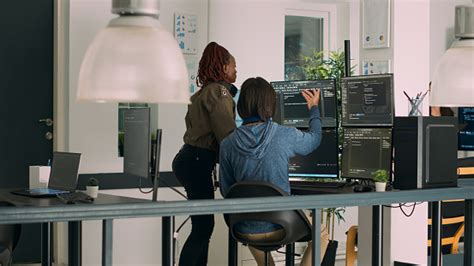 Diverse Team Of Database Admins Analyzing Source Code And Comparing