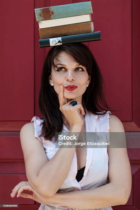 매력적인 성숙한 여자는 그녀의 머리에 몇 가지 책과 함께 포즈 35 39세에 대한 스톡 사진 및 기타 이미지 35 39세