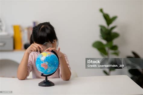 아시아 어린 소녀는 세계 모델 세상을 구하고 집에서 어린이 교육을위한 놀이 활동을 통해 배우는 개념을 배우고 있습니다 세계지도에
