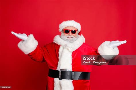 빨간 배경 위에 고립 된 검은 벨트 캡을 입고 새해 광고 프로모션을 들고 안경을 가진 잘 생긴 멋진 재미 산타 클로스의 초상화 산타 클로스에 대한 스톡 사진 및 기타 이미지