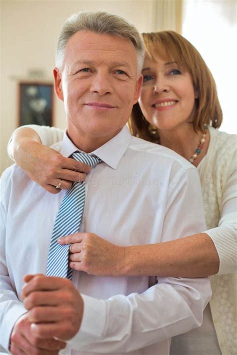 Portrait Of Smiling Mature Woman Standing With Arms Crossed At Home