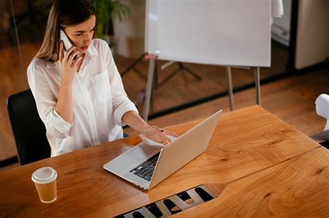 사무실에서 컴퓨터로 일하는 비즈니스 여성이 전화 통화를 하는 동안 가정 생활에 대한 스톡 사진 및 기타 이미지 가정 생활 글로벌 커뮤니케이션 노트북 Istock