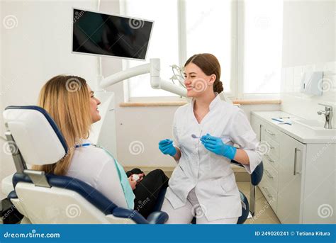 A Female Dentist Explains To A Patient Gesticulating With Her Hands