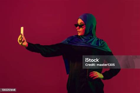 네온 빛에 부르고뉴 스튜디오 배경에 고립 된 세련된 히잡에서 포즈를 취하는 아름다운 아랍 여성 패션 아름다움 스타일 컨셉 16 17 살에 대한 스톡 사진 및 기타 이미지