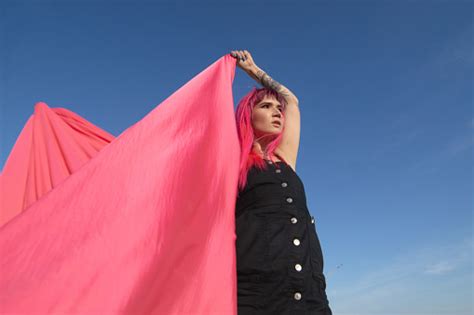 분홍색 옷을 입은 젊은 여성이 풍력 발전기와 함께 들판 근처에서 춤을 추고 있습니다 일몰에 풍차 패션 초상화 귀여운에 대한 스톡 사진 및 기타 이미지 Istock