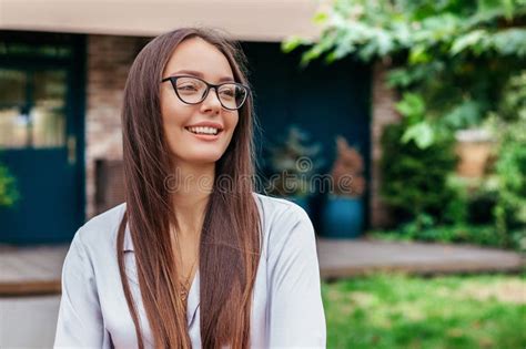 Portrait Of A Young Smiling Brunette Girl In Glasses Against The Backdrop Of Nature Trees