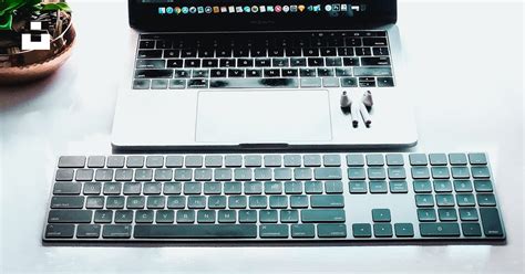 테이블 위의 키보드 옆에 있는 은색과 검은색 노트북 사진 Unsplash의 무료 검정 이미지