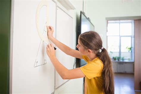 학생은 학교 교실에서 칠판에 삼각형을 그립니다 십대 아이는 중간 링크에서 수학 기하학 수업에서 각도기로 각도를 측정합니다 수학에 대한 스톡 사진 및 기타 이미지 Istock