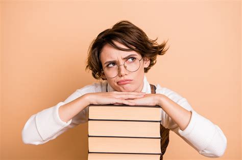 파스텔 베이지 색 배경에 고립 된 빈 공간을 찾고 책 근처 게으른 무디 여학생의 사진 초상화 갈색 머리에 대한 스톡 사진 및 기타 이미지 Istock