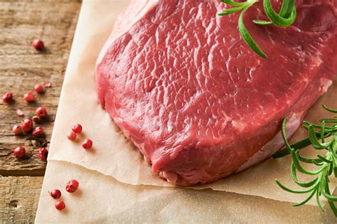 생 쇠고기 스테이크 포크 로즈마리 소금 후추를 곁들인 신선한 쇠고기 갈비뼈 스테이크는 오래된 나무 배경에 양피지 조각입니다 평면도 디자인 아이디어에 대한 모형 갈비 음식에