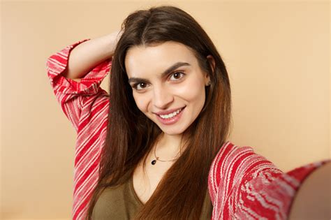 예쁜 젊은 여자의 Selfie 샷을 닫습니다 카메라를 찾고 파스텔 베이 지 배경에 고립 된 머리에 손을 넣어 사람들은 진심으로 감정 라이프 스타일 개념입니다 복사 공간을