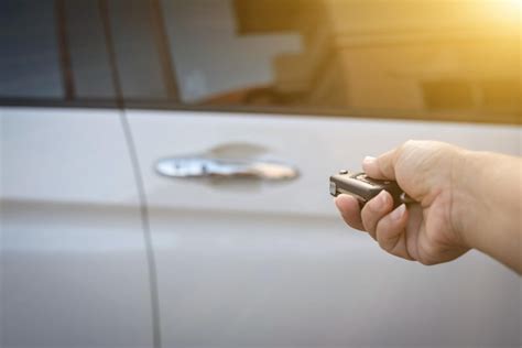 Premium Photo Female Hand Pushing Remote Key Of White Car