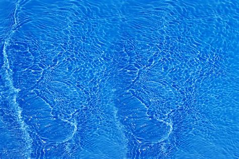 디포커스는 스플래쉬와 거품으로 투명한 파란색의 맑고 잔잔한 물 표면 질감을 흐리게 처리했습니다 트렌디 한 추상적 인 자연 배경 복사 공간이있는 햇빛 속의 물파 푸른 수채화