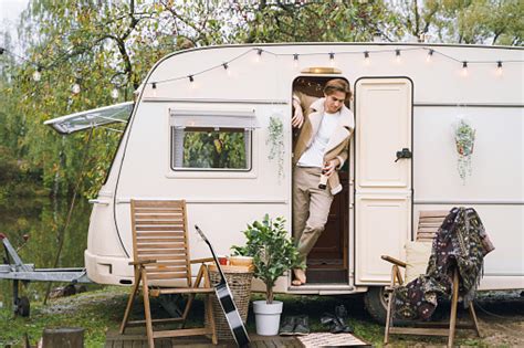 젊은 세련된 미국 남자 야영 자 바퀴에 집 트레일러 모터 홈에서 여행하는 남자 낭만적 인 도로 여행 자유 생활 밴에서 하룻밤 캠프장 방랑욕 휴가 주말 행복한 모험 20 24