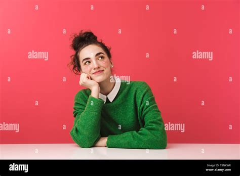 Pretty Nerd Girl Sitting At The Table Isolated Over Pink Background