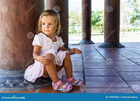 Kleines Mädchen Das Nahe Der Spalte Sitzt Stockfoto Bild Von