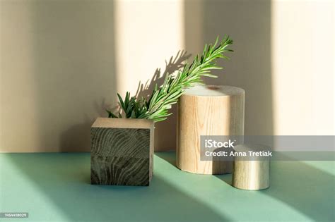 나무와 향기로운 로즈마리 가지로 만든 빈 연단의 구성 아름다운 파스텔 배경은 제품의 프리젠 테이션을위한 나무의 기하학적 모양의 천연 재료로 만들어졌습니다 0명에 대한 스톡