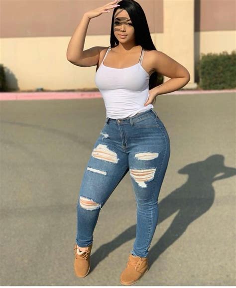 A Woman In Ripped Jeans Posing For The Camera