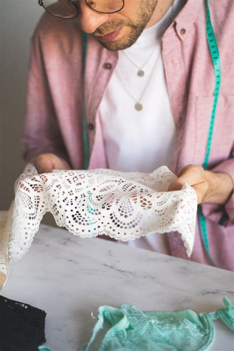 A Male Designer With Glasses Chooses The Type Of Lace For Underwear A