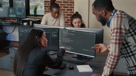 Mixed Programmers Team Working On Group Project On Multiple Screens Showing Running Code Stock